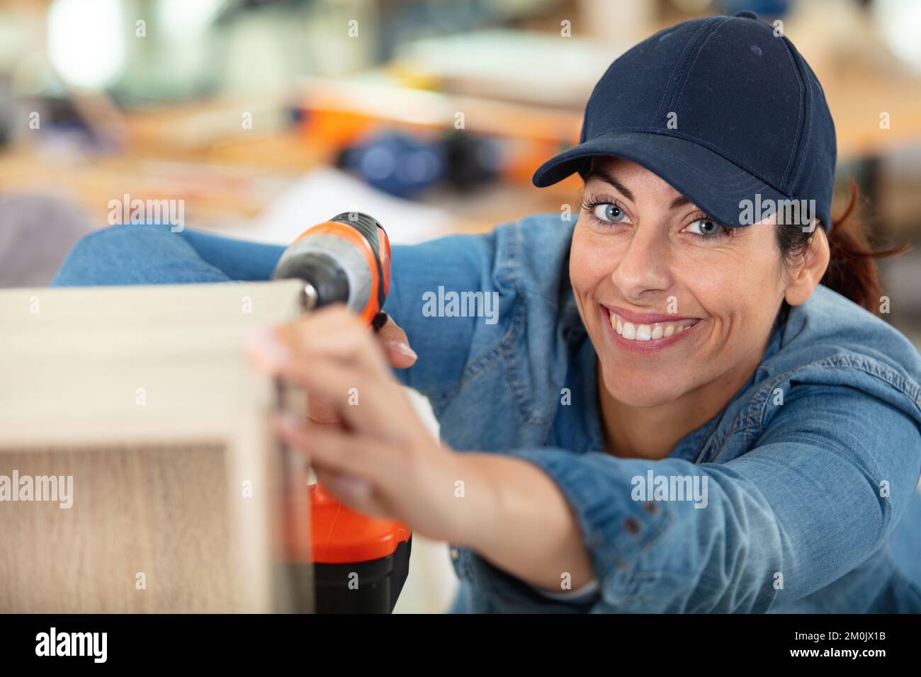 pretty young woman holding screwdriver and repairing furniture Stock ...