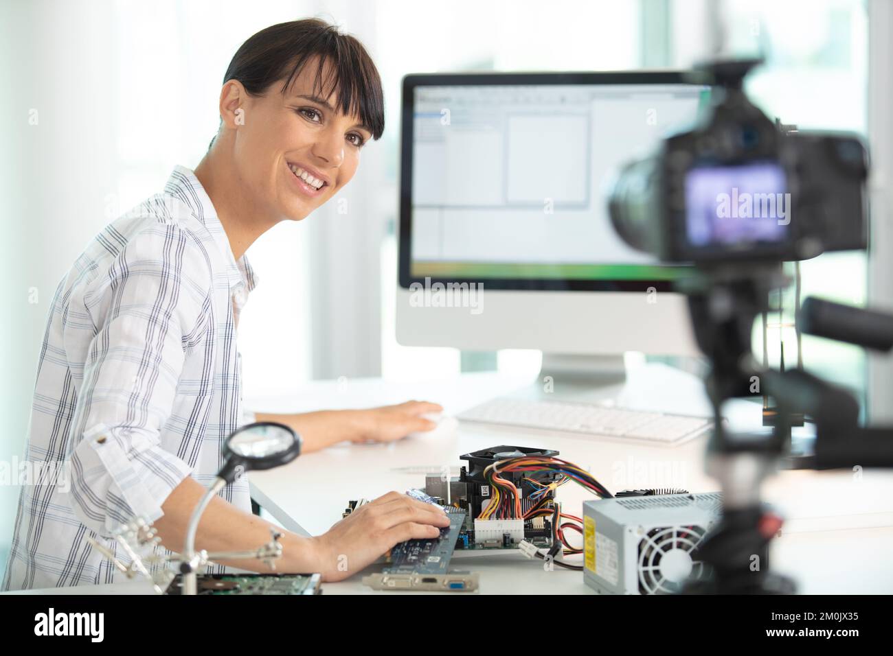 female vlogger recording computer repair Stock Photo - Alamy
