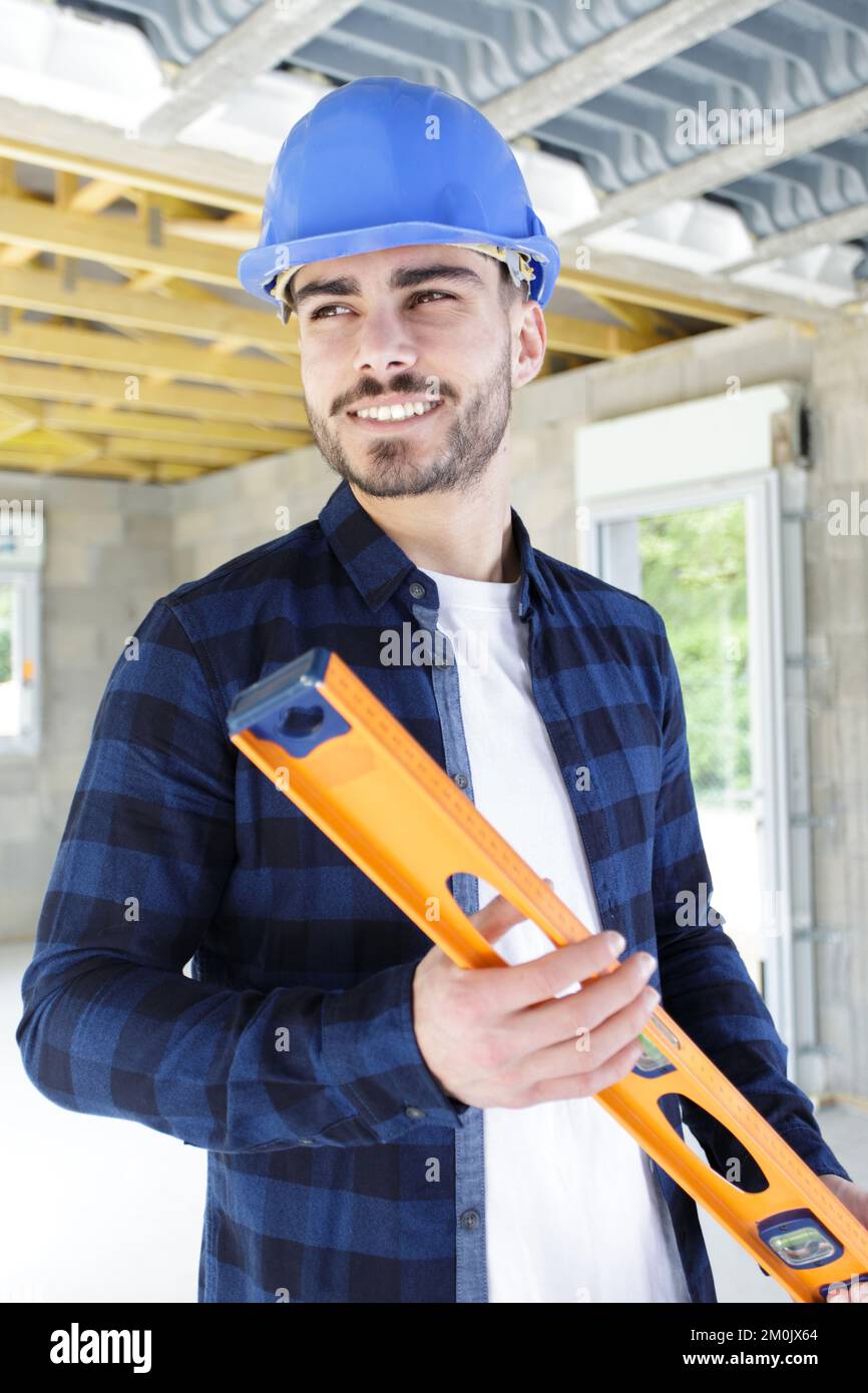 happy smiling constructor holding construction level Stock Photo - Alamy