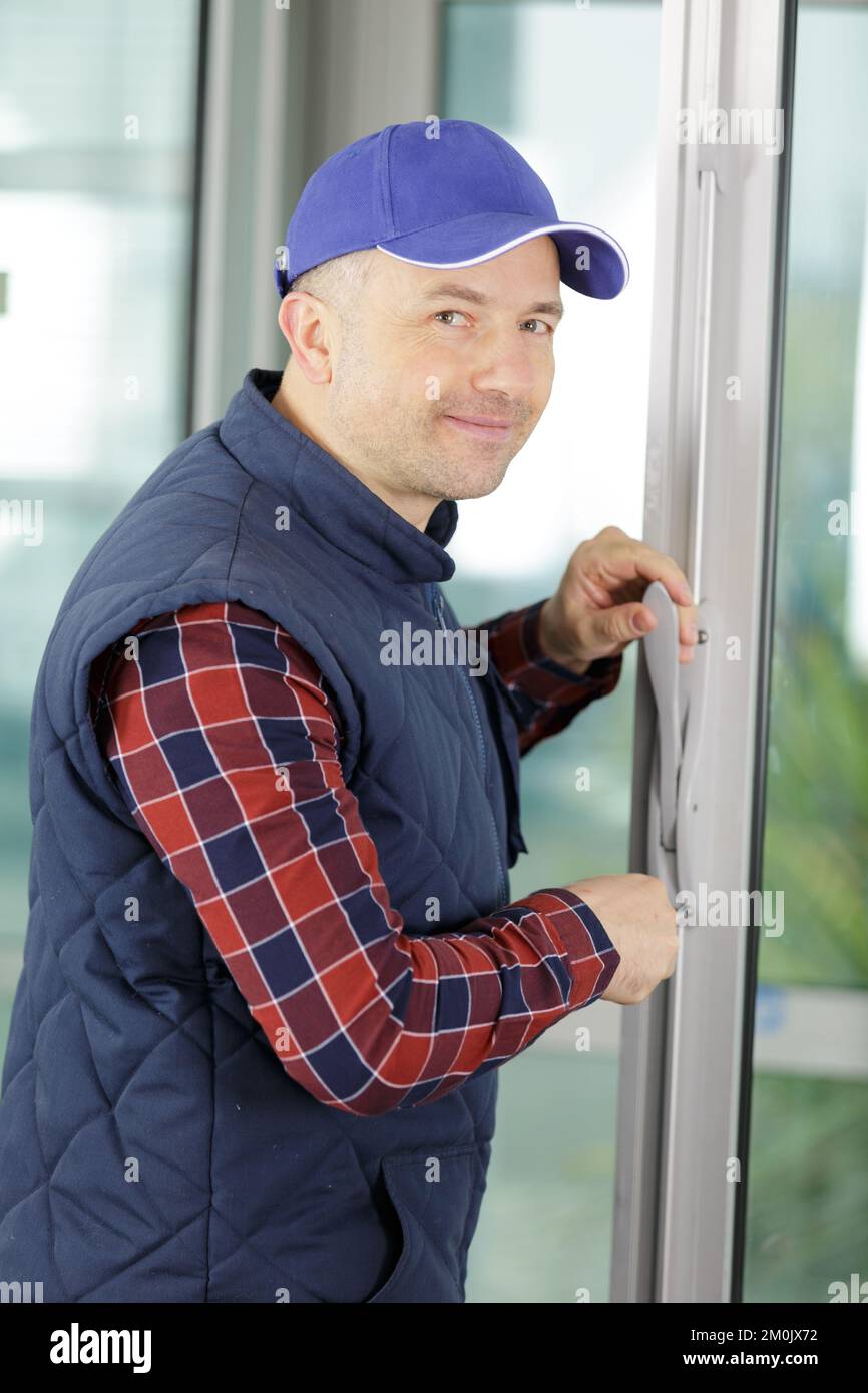 worker applying rubber strip onto window in office Stock Photo - Alamy