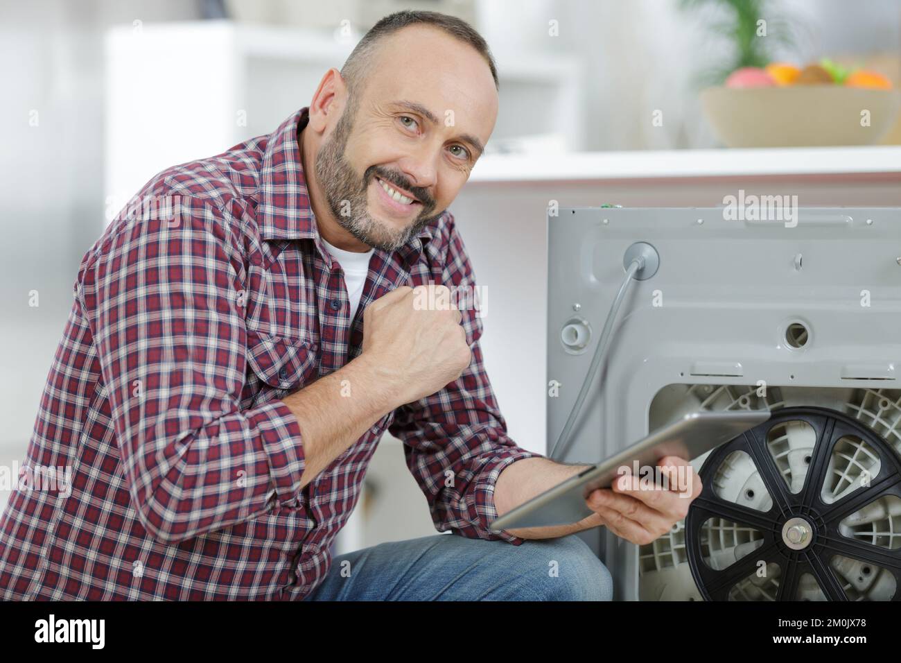 man using digital tablet at laundry Stock Photo - Alamy