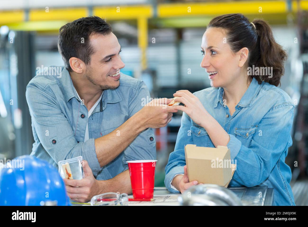 workers eating sandwich and talking to his colleague Stock Photo - Alamy