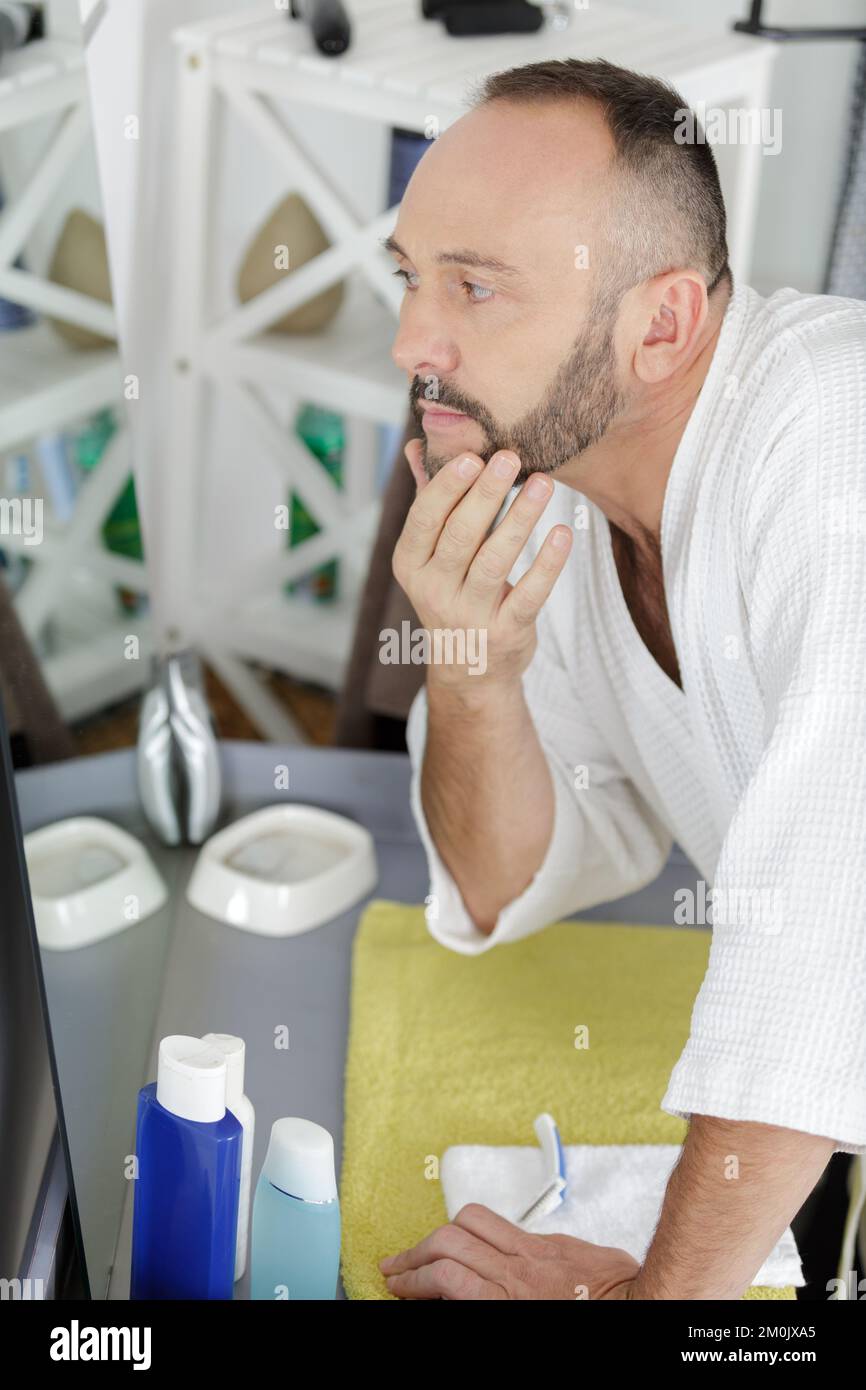 Mature man touching skincare hi-res stock photography and images - Alamy