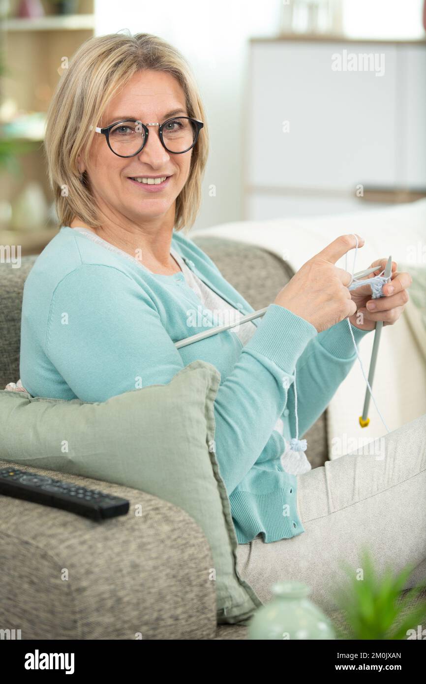 cheerful smiling senior woman knitting on couch Stock Photo - Alamy