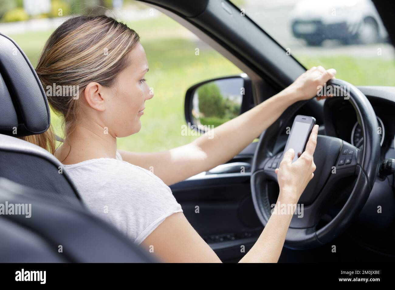 a woman texting while driving Stock Photo - Alamy