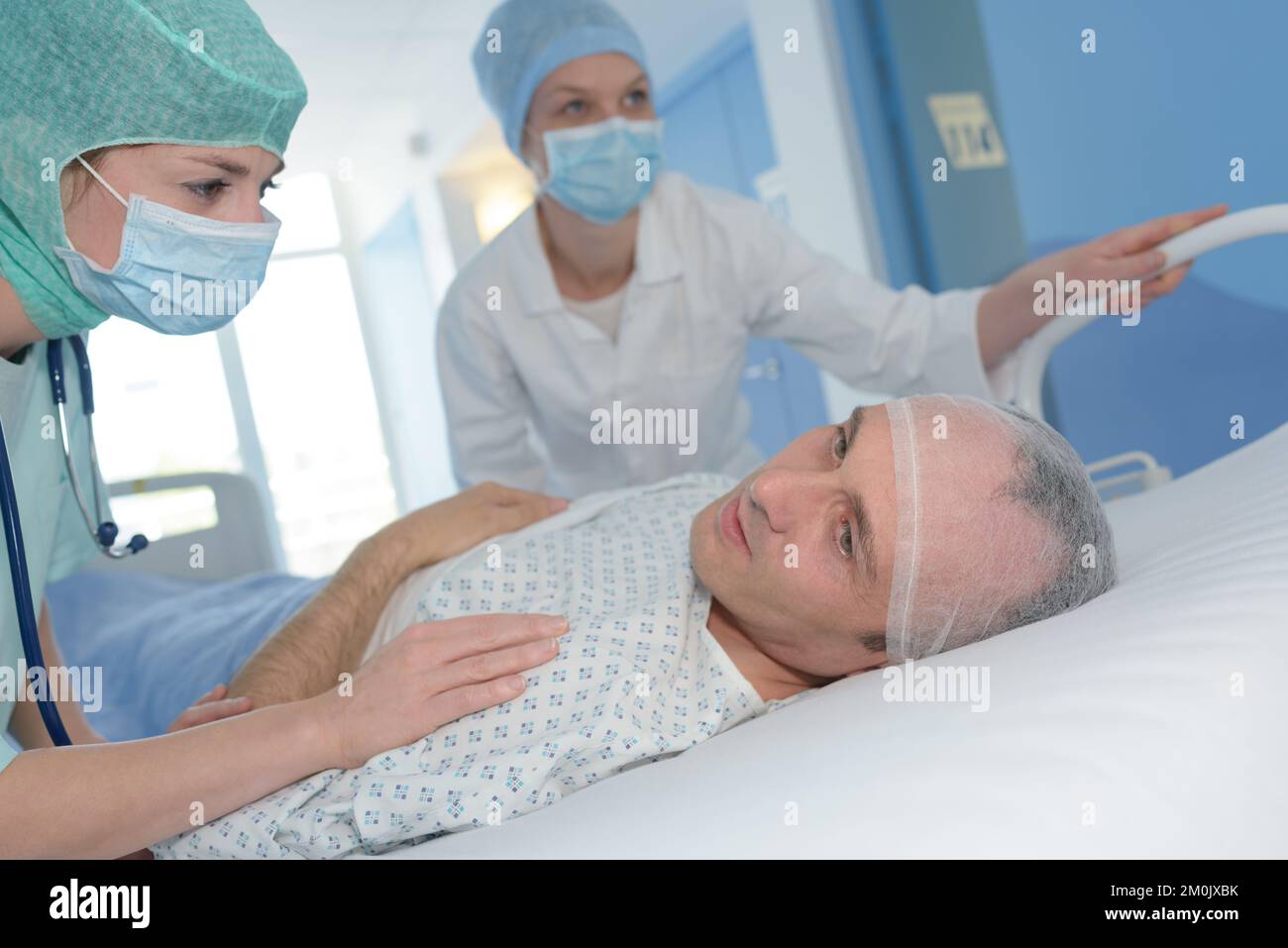 male patient lying in hospital bed recovering after surgery Stock Photo ...