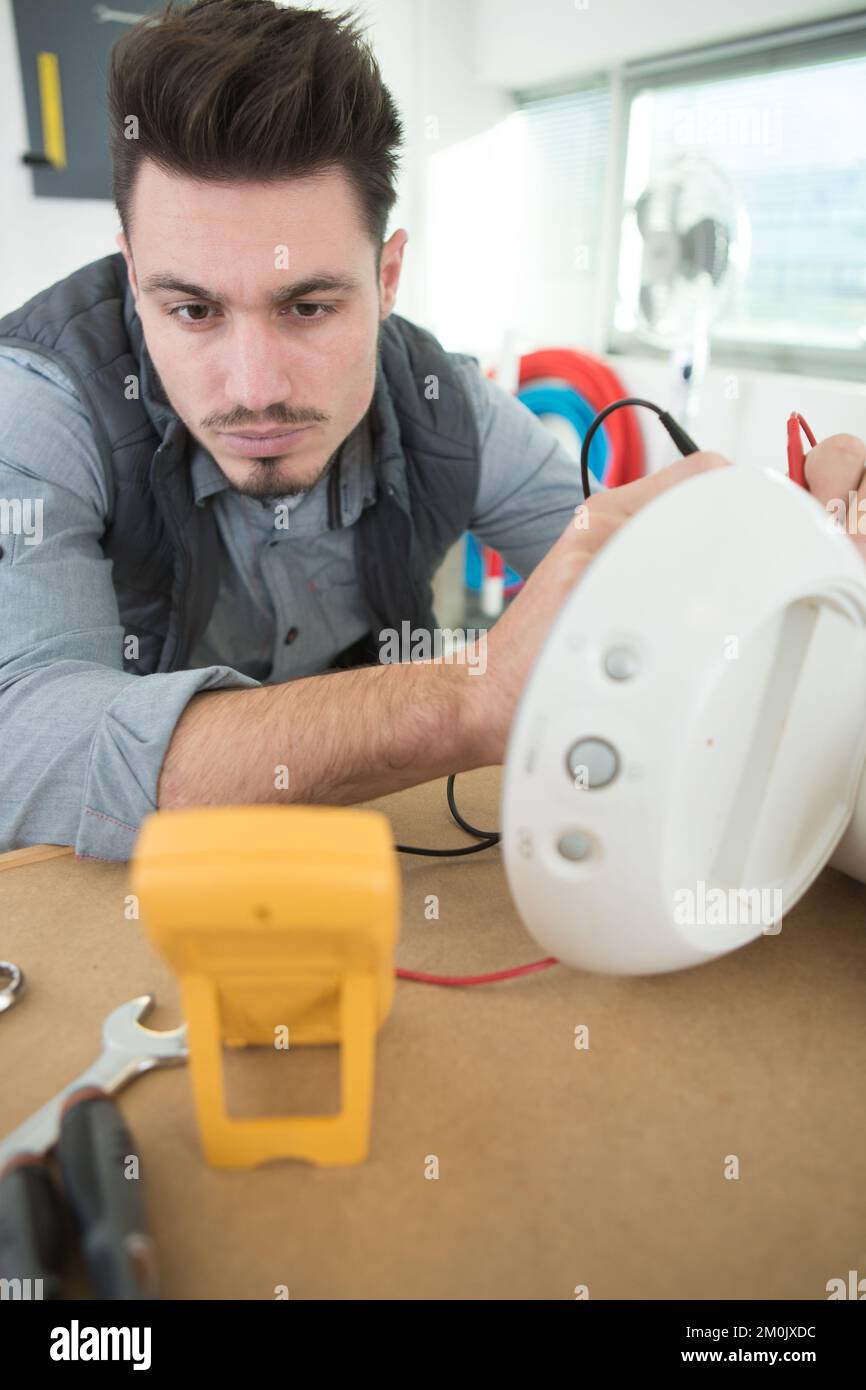 repairman testing an appliance with a multimeter Stock Photo - Alamy