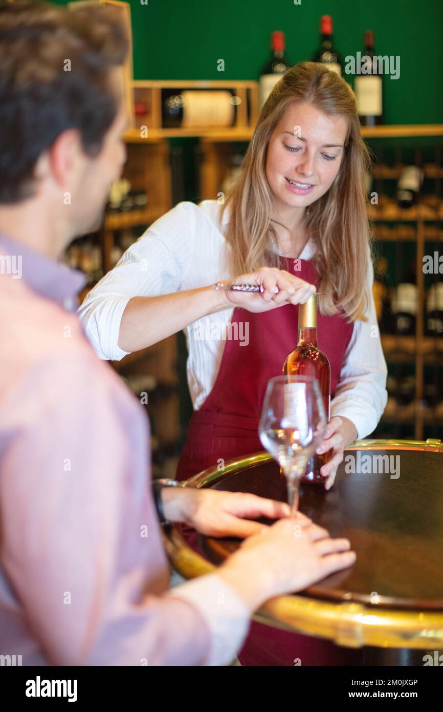 female proprietor opening wine for a distillery tasting Stock Photo - Alamy