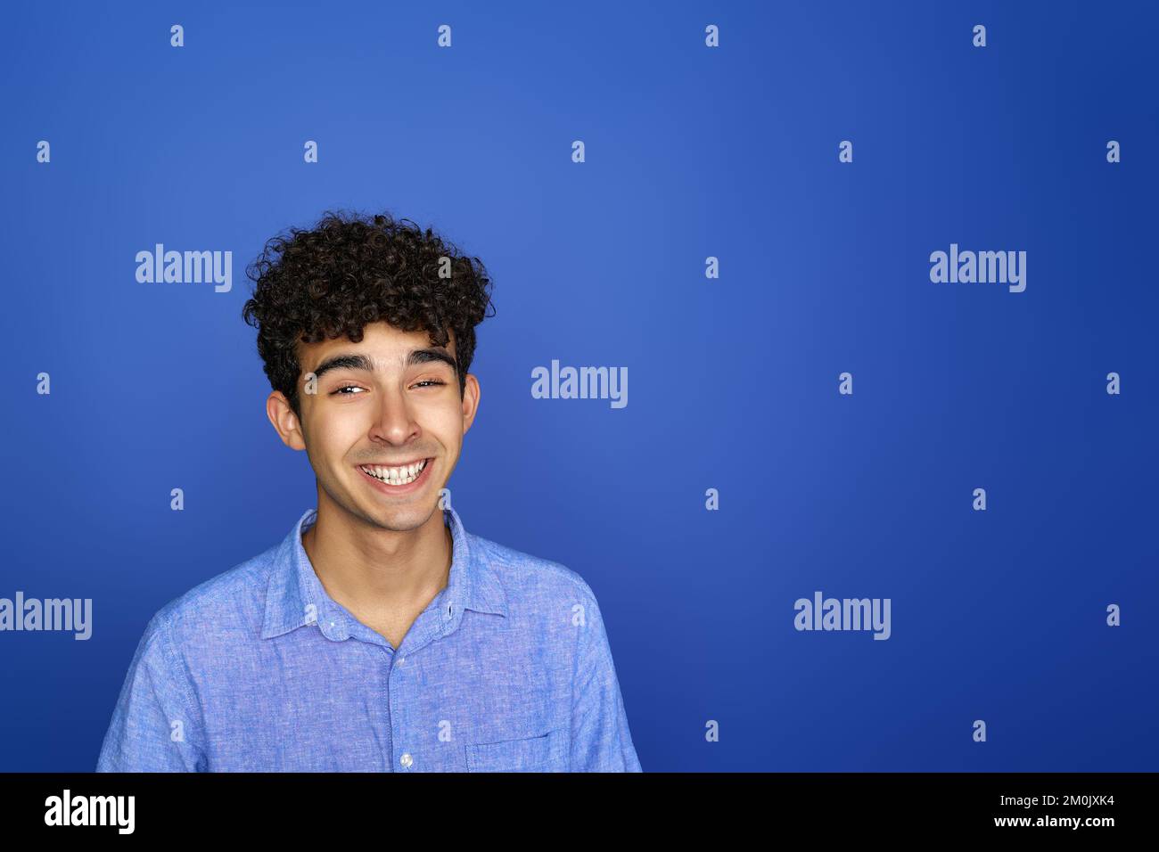 Smiley teenager looks excited, isolated on a blue background Stock ...