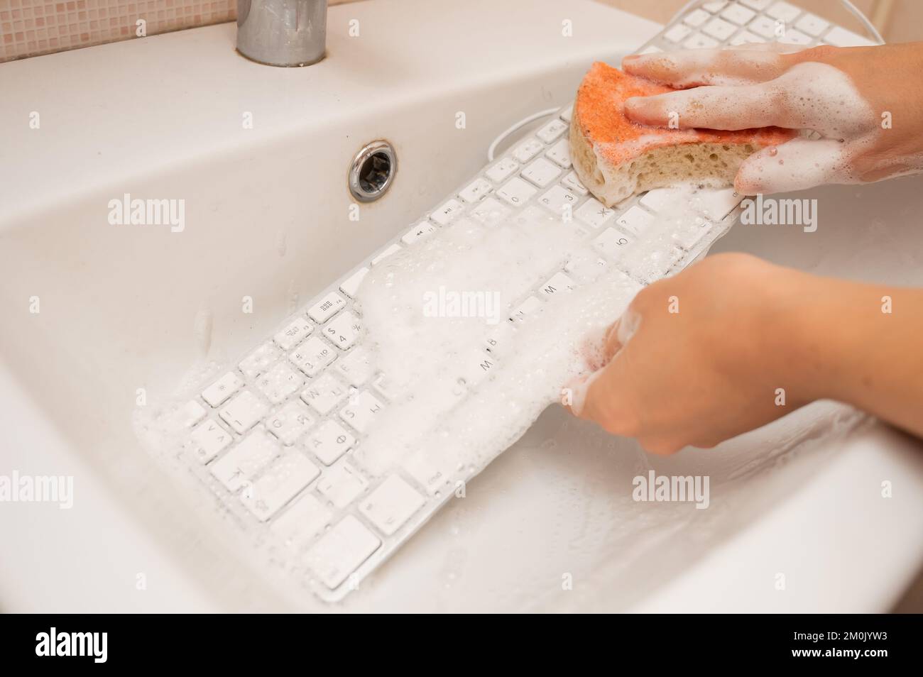 Woman washing white computer keyboard with a sponge with foam Stock ...