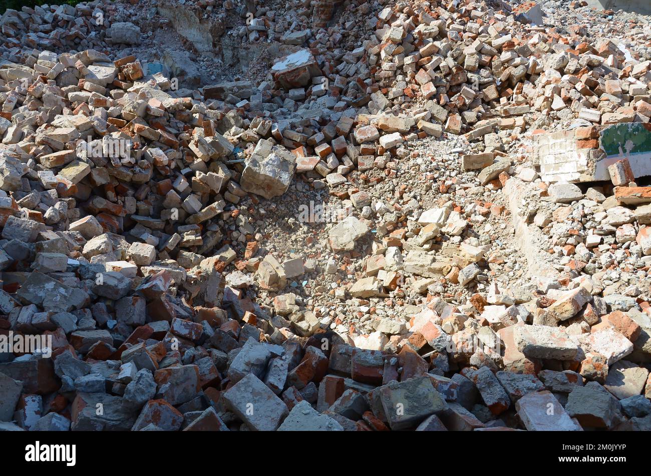Pile of broken red bricks and fragments of concrete from destroyed building. Broken bricks close ...