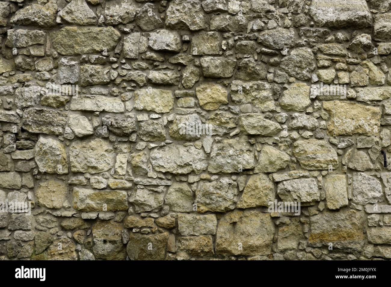 Texture of a stone wall with many big brown and grey stones armed with ...