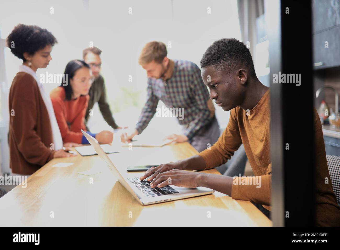 Portrait of a happy African American entrepreneur displaying computer ...