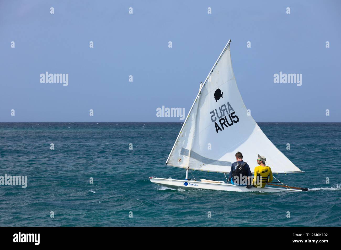 ORANJESTAD, ARUBA - MARCH 27, 2022: Two people sailing in a small ...