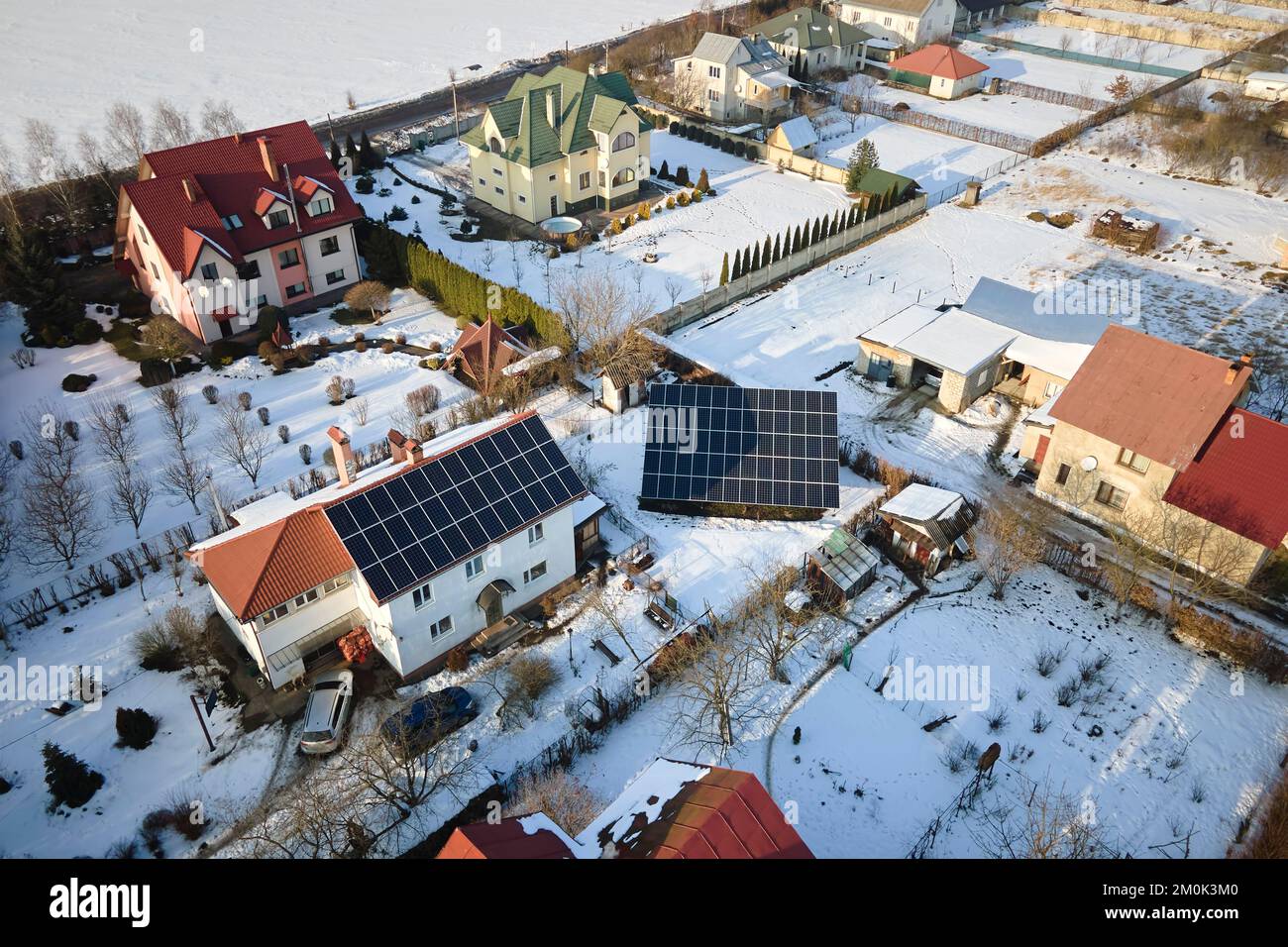 Aerial view of house roof with solar panels covered with snow melting ...