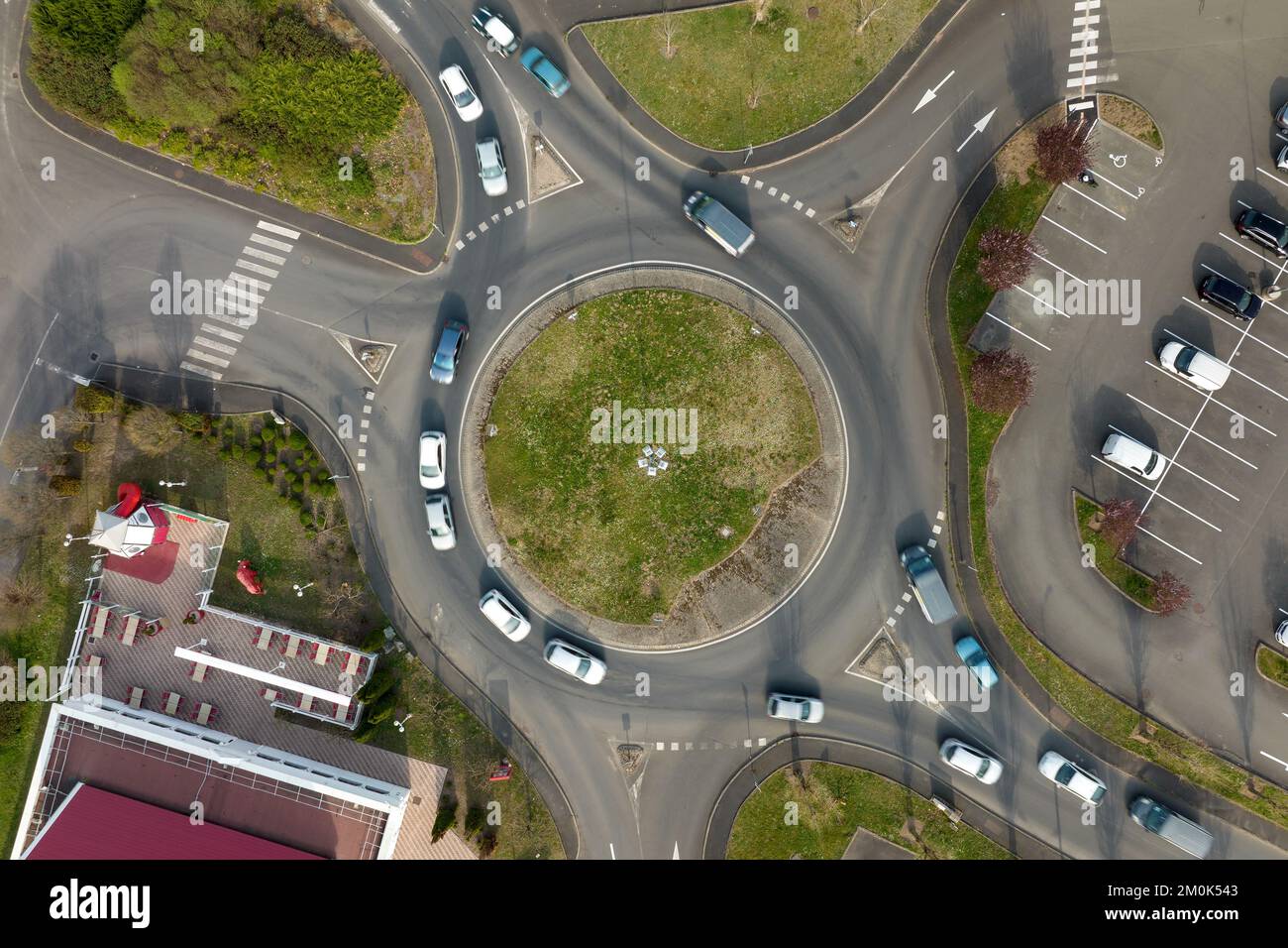 Aerial view of road roundabout intersection with fast moving heavy traffic. Urban circular ...
