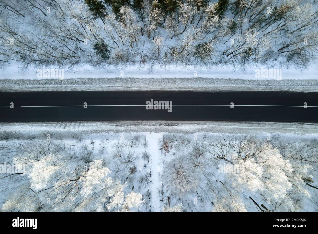 Aerial view of winter landscape with snow covered woods and black ...