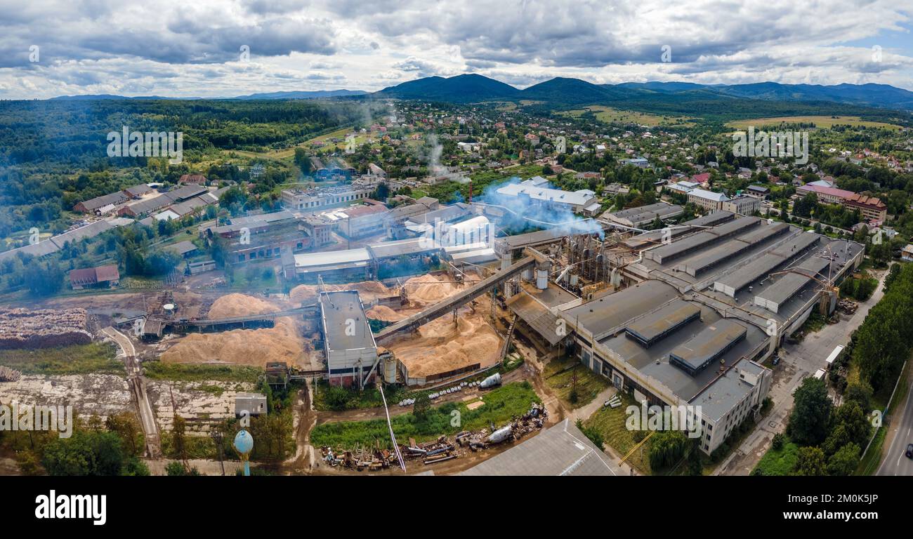 Aerial view of wood processing plant with smokestack from production ...