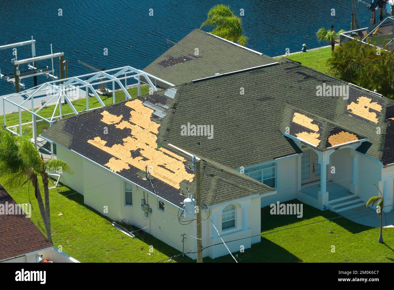 Damaged house roof with missing shingles after hurricane Ian in Florida ...