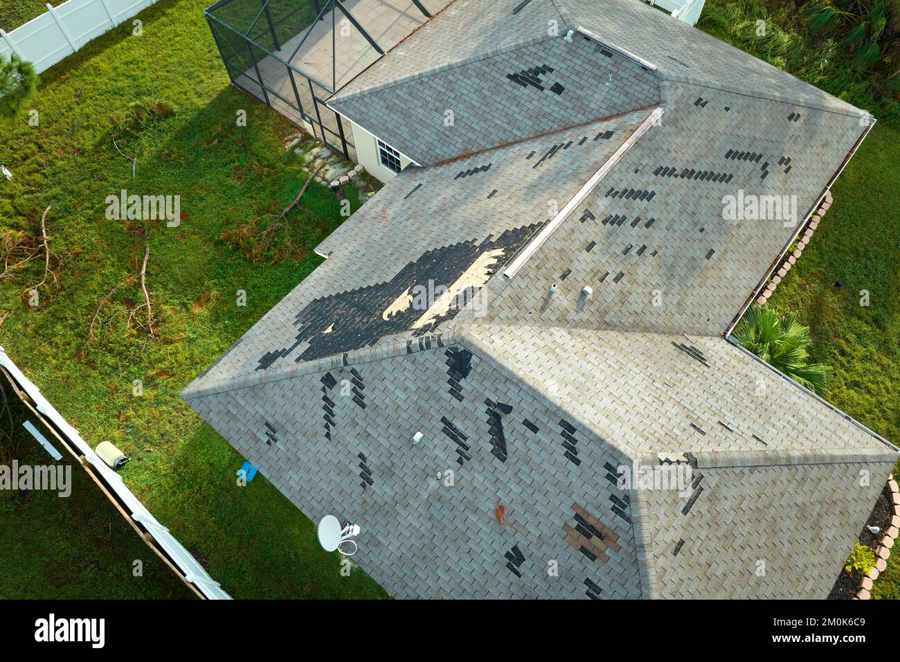 Damaged house roof with missing shingles after hurricane Ian in Florida ...