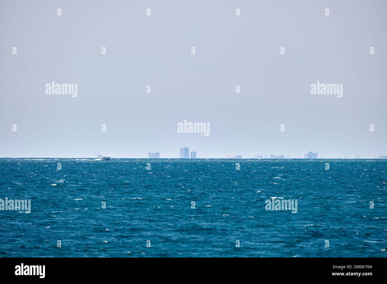Sea panorama. Small motor boat floats in deap blue bay water under ...