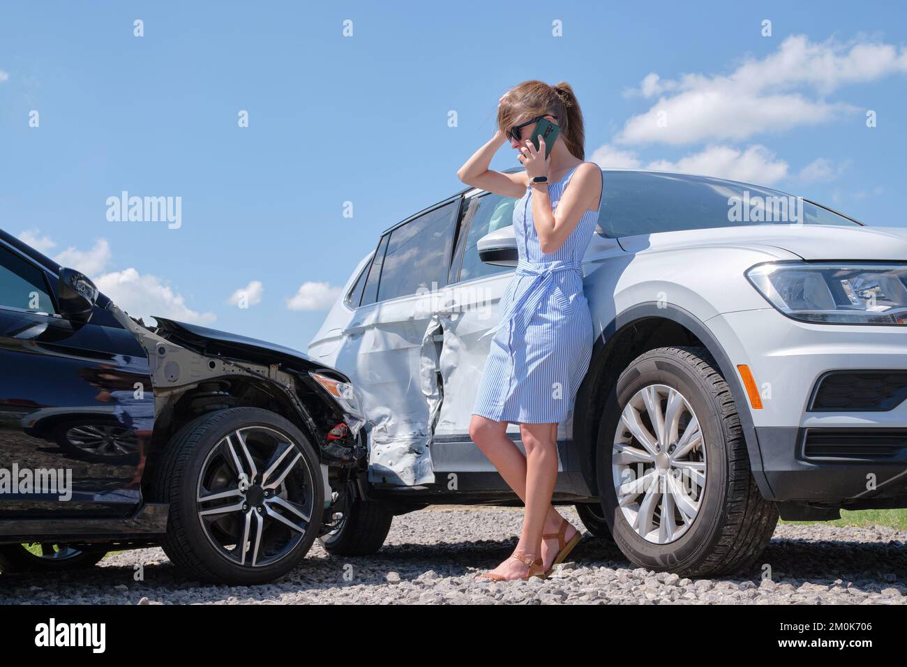 Sad female driver speaking on sellphone on street side calling for ...