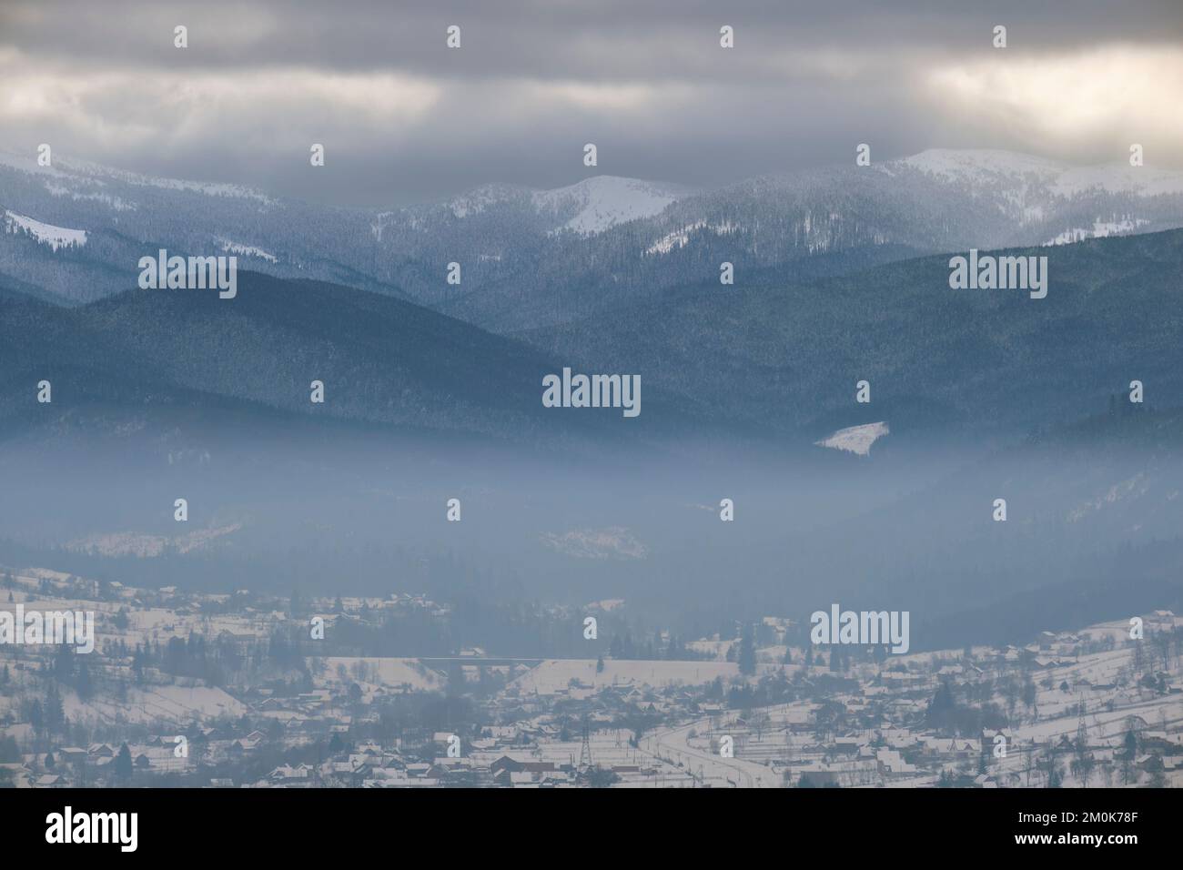 Winter landscape with mountain hills covered with evergreen pine forest ...
