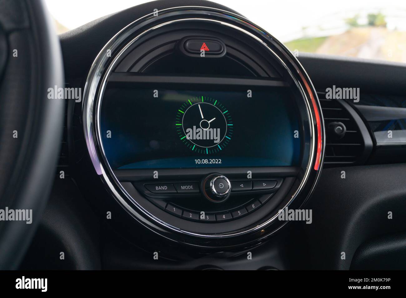 A Mini Cooper S infotainment system and steering wheel with a clock on ...