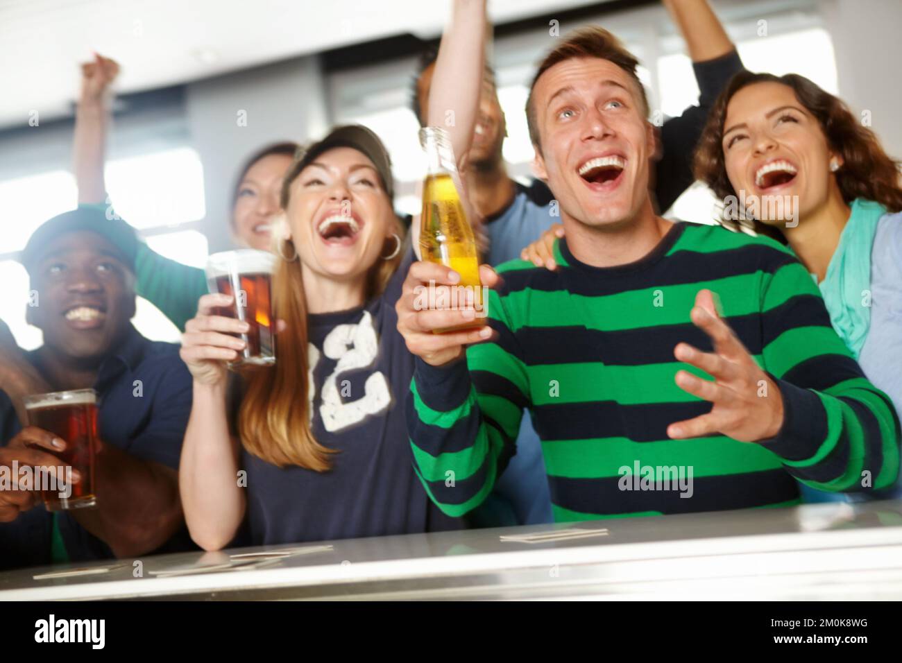 Cannot control their excitement. A group of friends cheering on their ...