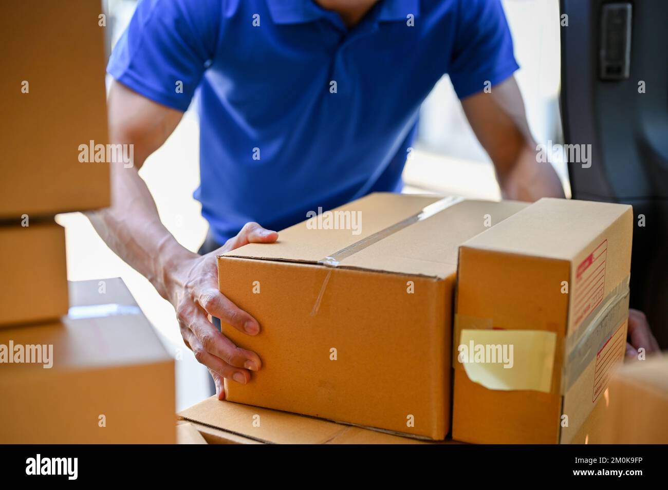 Close up view of delivery man organizing parcels before giving it to ...