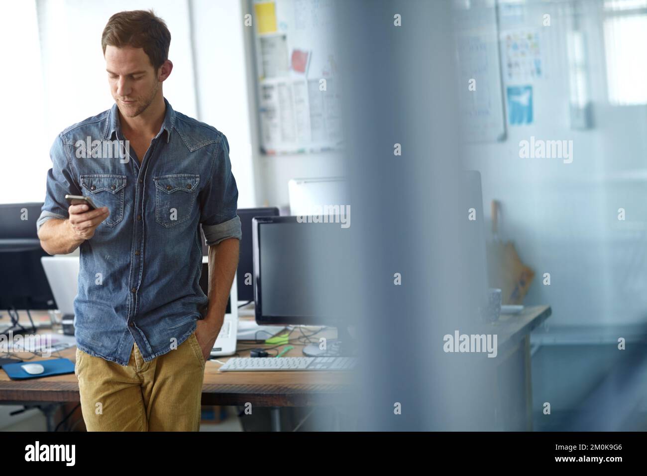Getting in touch with his colleagues. A young man reading his text ...