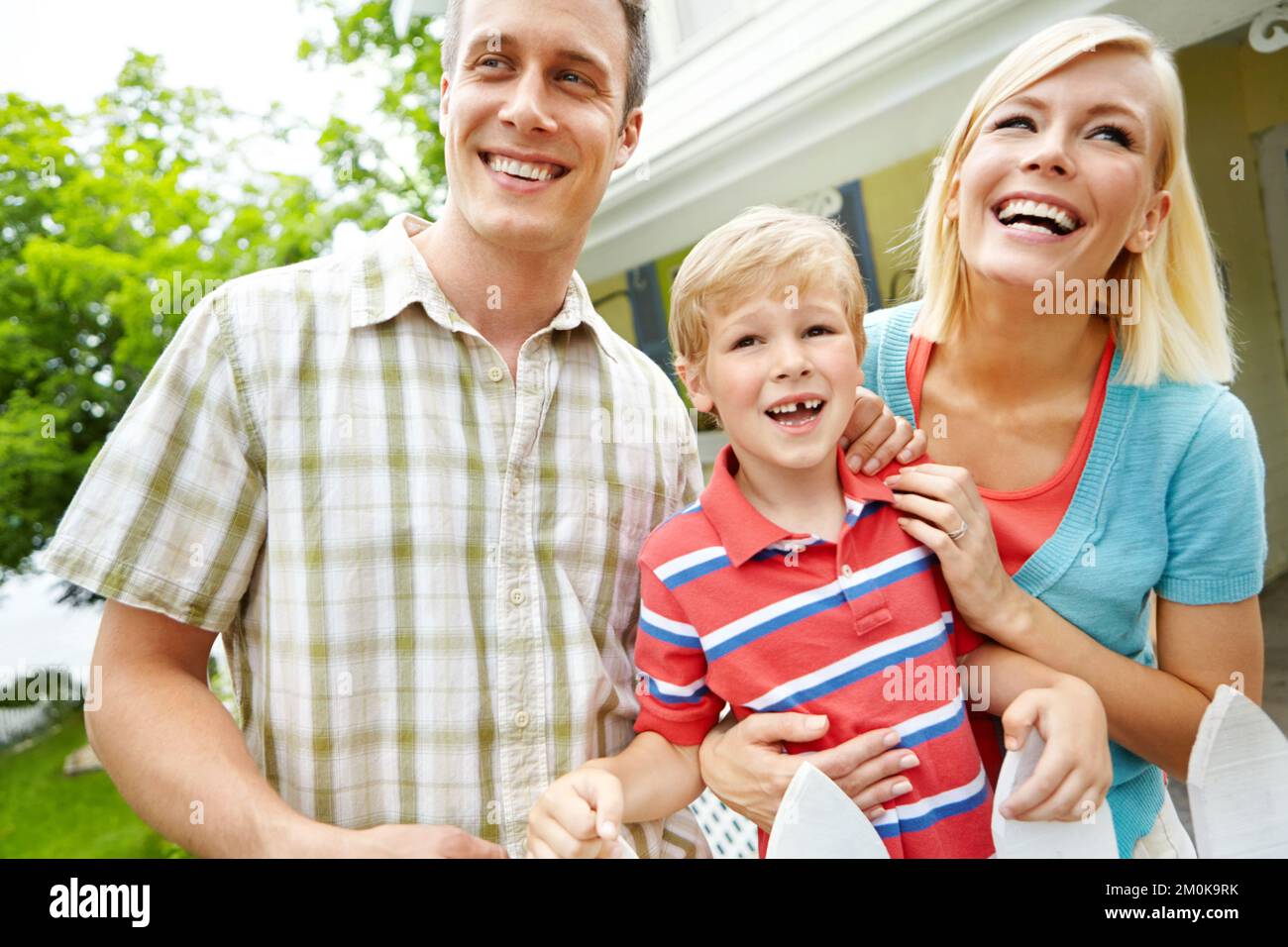They have a happy family home. A smiling family standing outside of ...