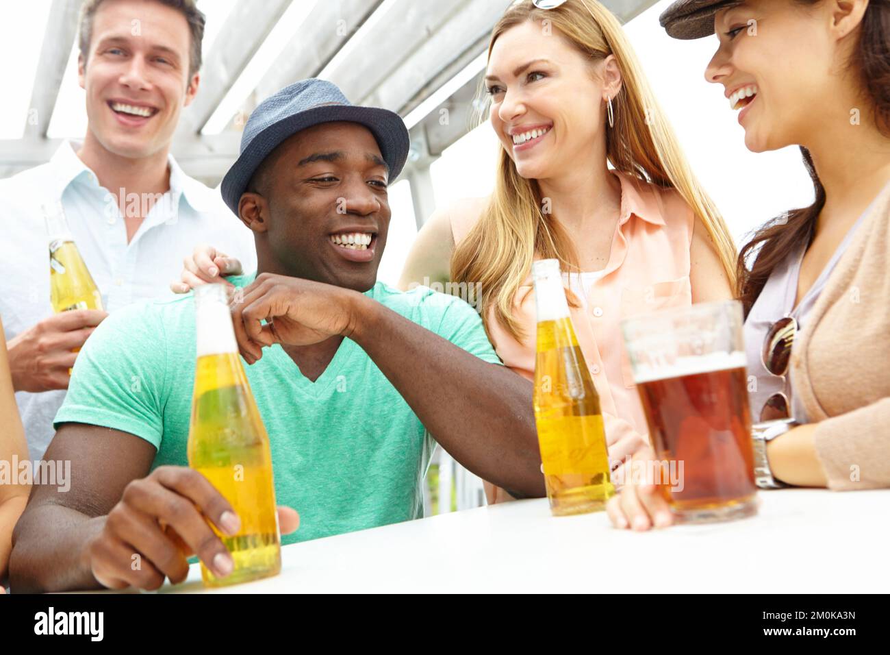 Unwinding at the bar. A group of friends enjoying drinks on the deck of ...
