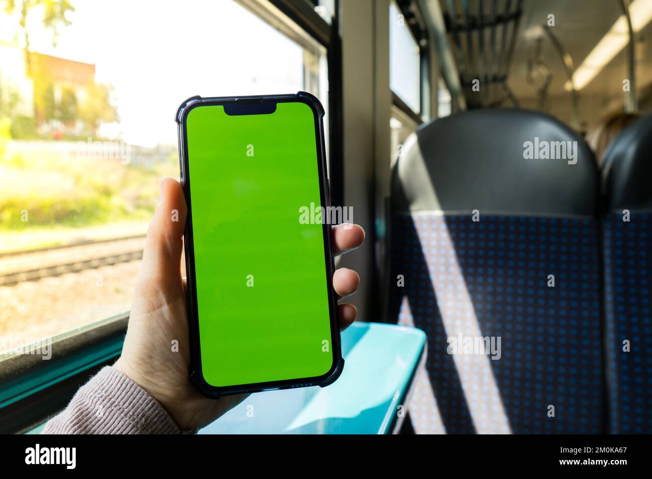 Female hand holding chroma key screen phone in the train. Social ...