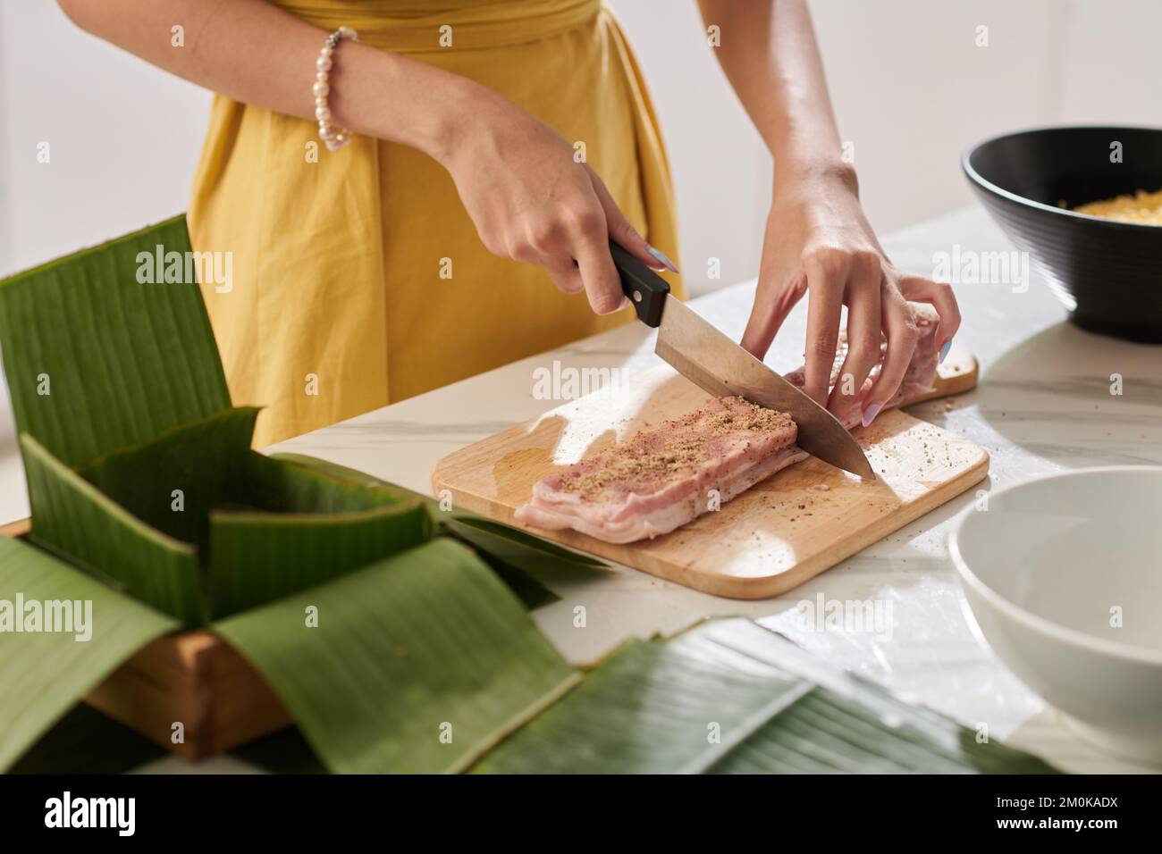 Hands cutting seasoned pork for Banh tet cake Stock Photo - Alamy