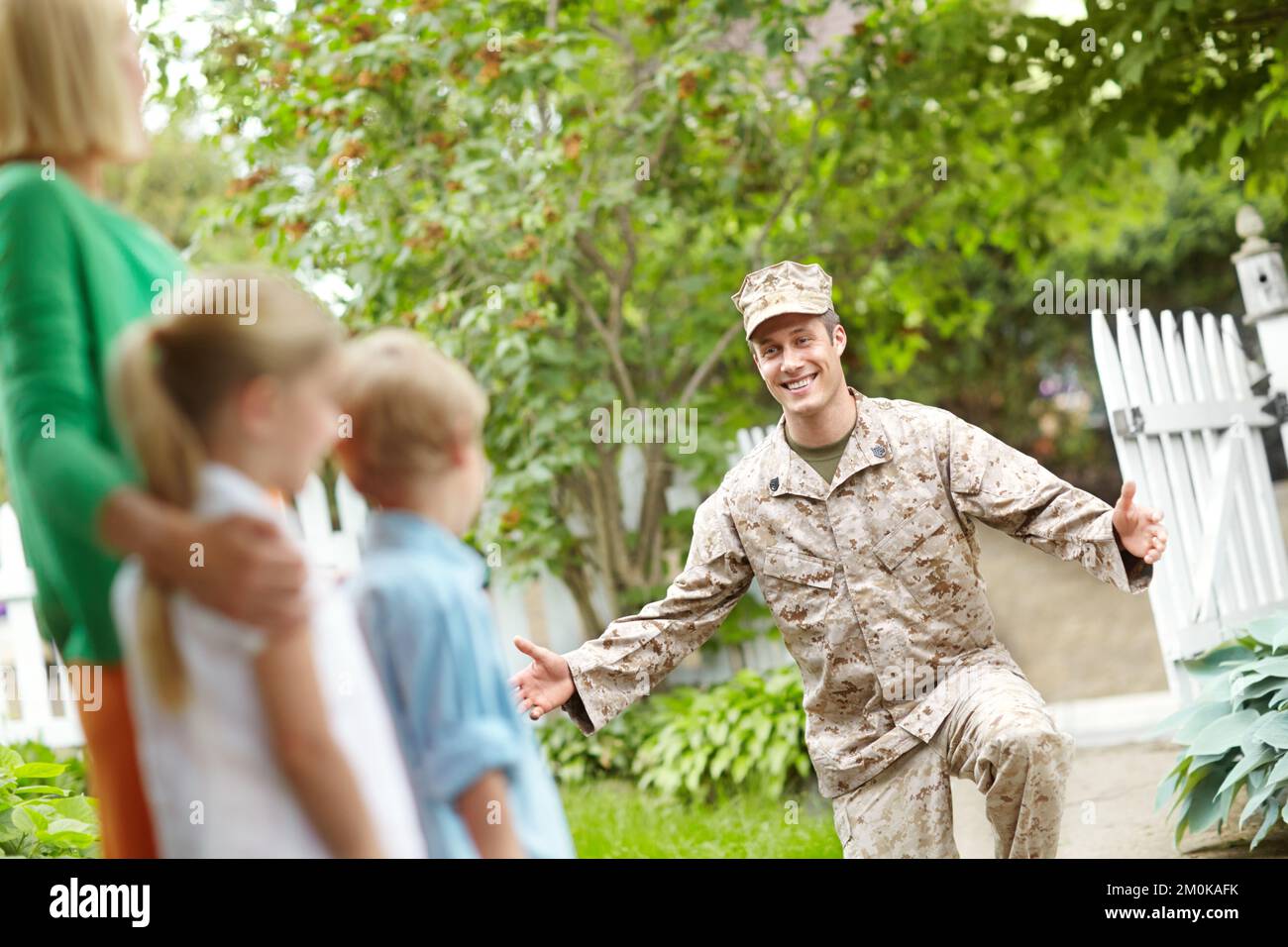 Come give me a hug. A returning soldier being welcomed by his two young ...