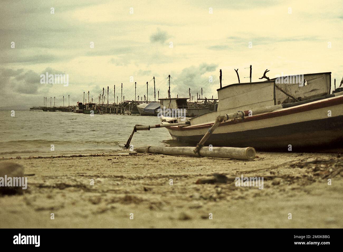 A boat in a background of a line of sailing bagans (bagang perahu) in ...