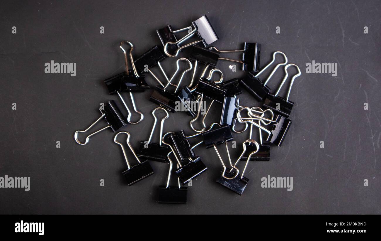 black paper clip on black background Stock Photo - Alamy