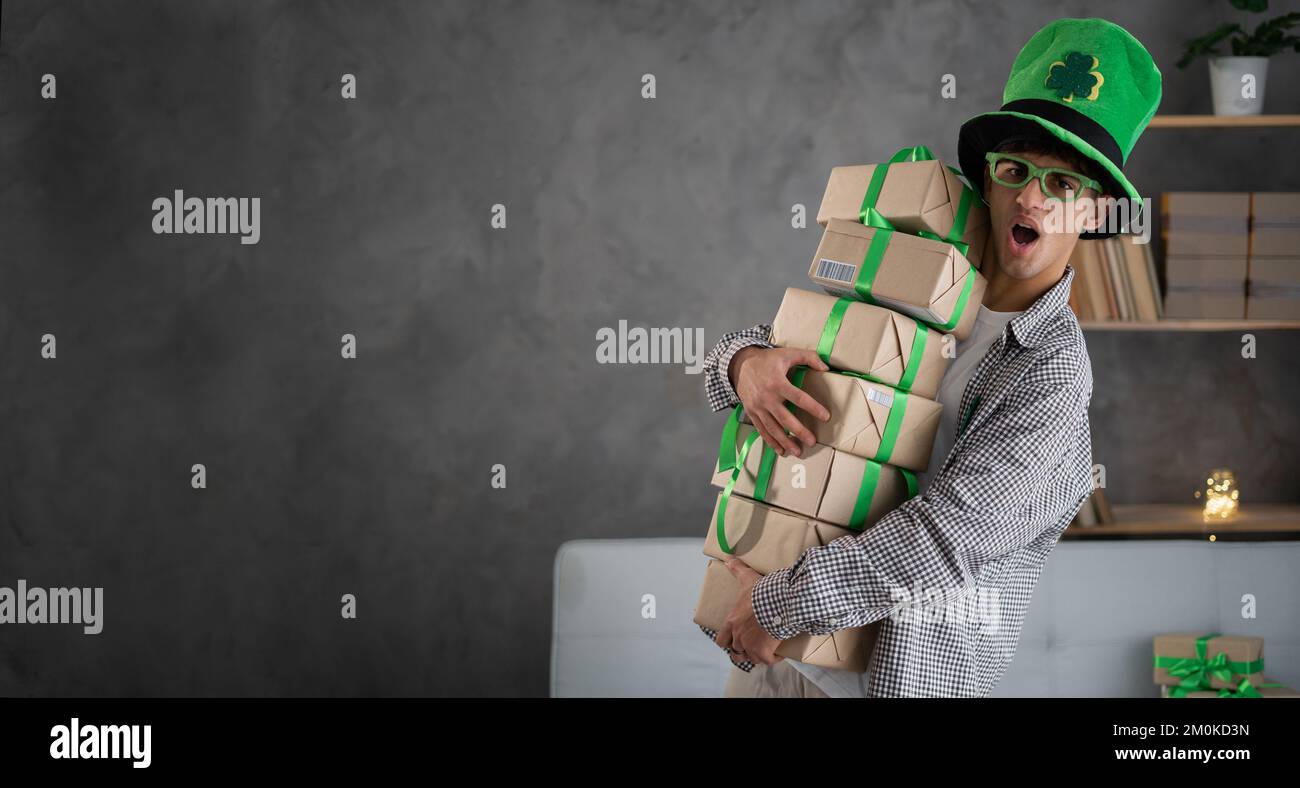Excited man in cap and cute green glasses holding stack of St.Patrick's ...