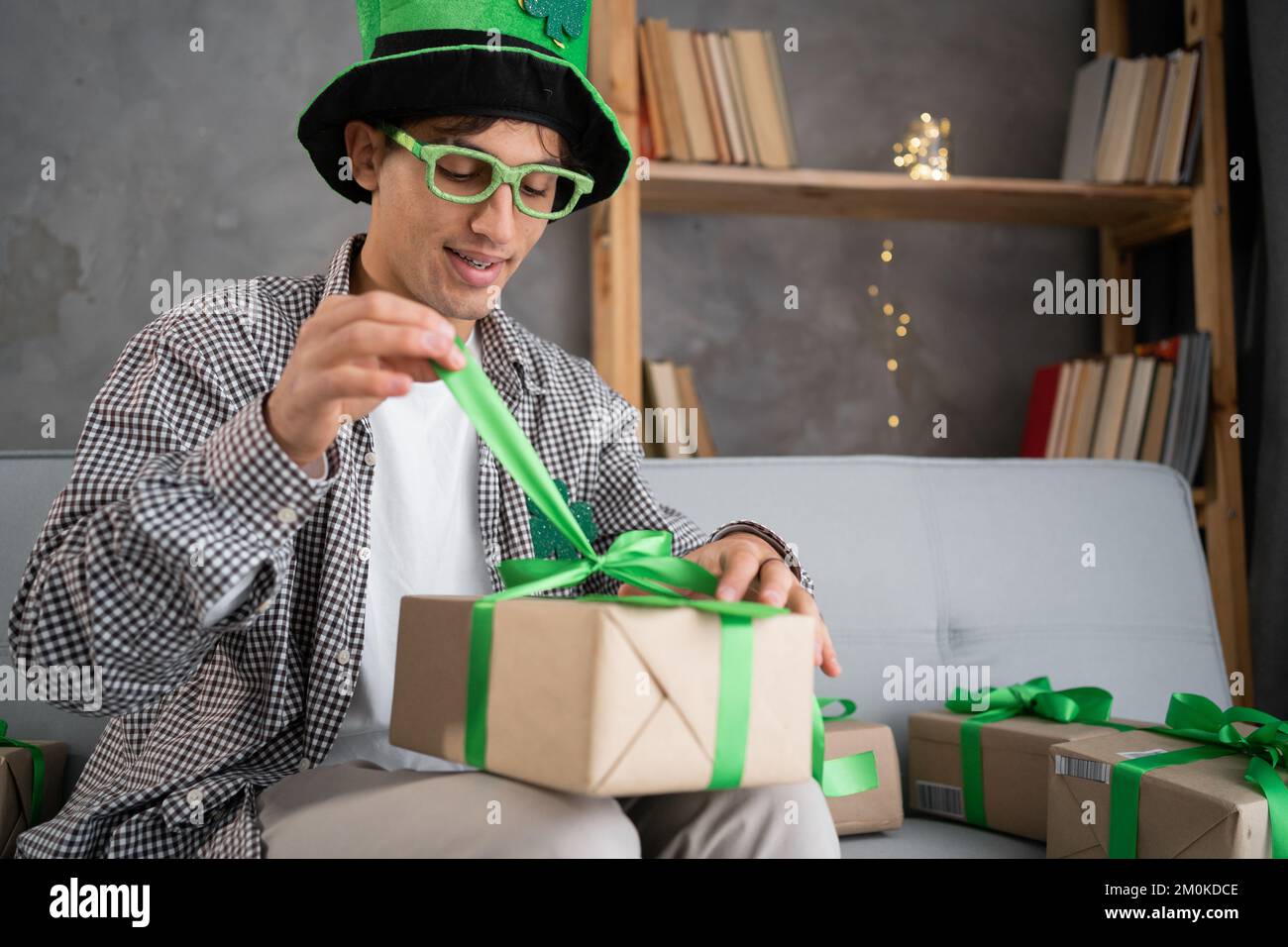 Unpacking gifts for St. Patrick's Day. Portrait of a young man with ...
