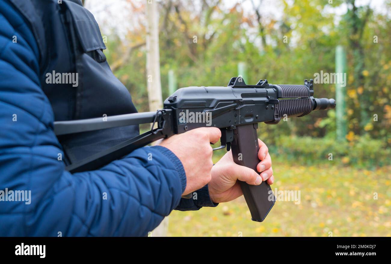 A man holds a Kalashnikov assault rifle in his hands for firing from ...
