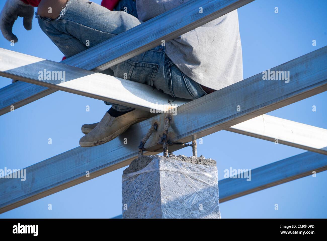 Asian male welder is welding steel beams in process of home renovation ...