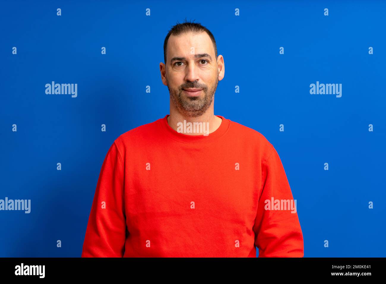 Spanish man with a beard posing happily for a half body portrait ...