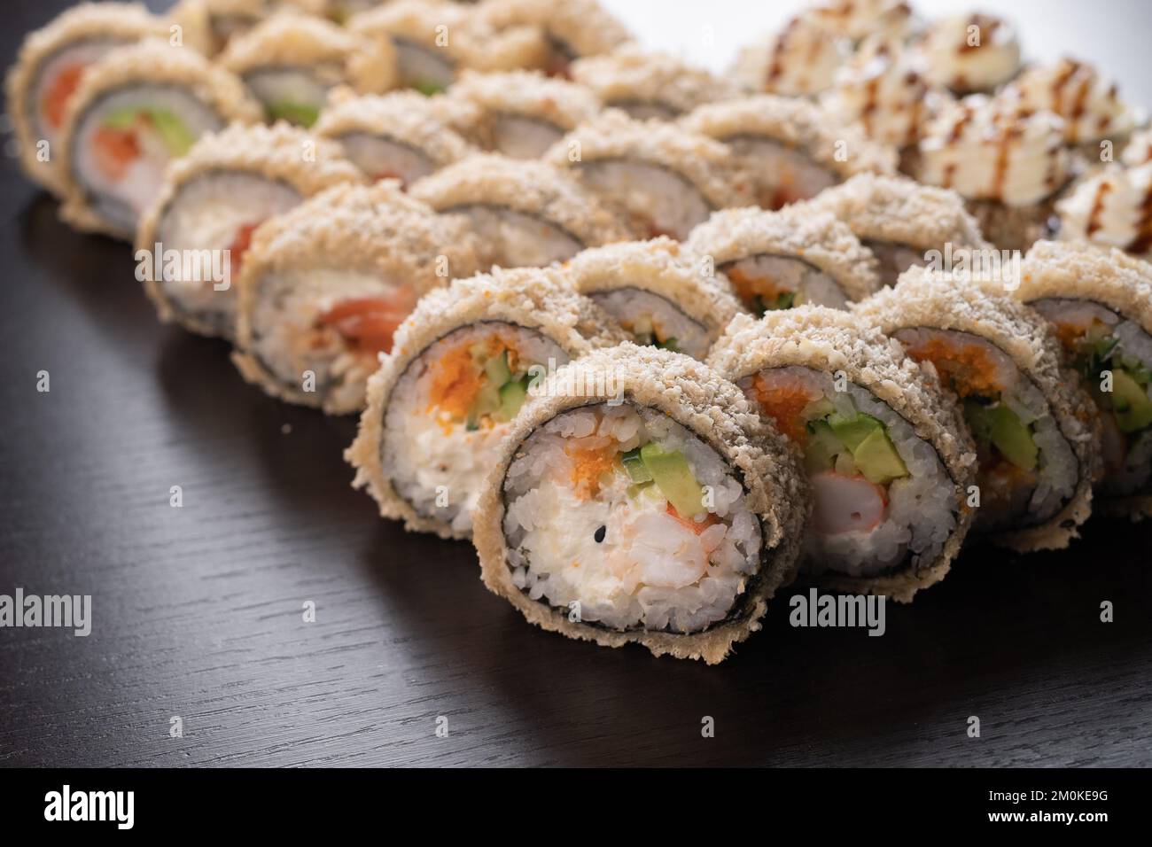 Tempura maki roll on black background. Hot sushi set with salmon, crab ...