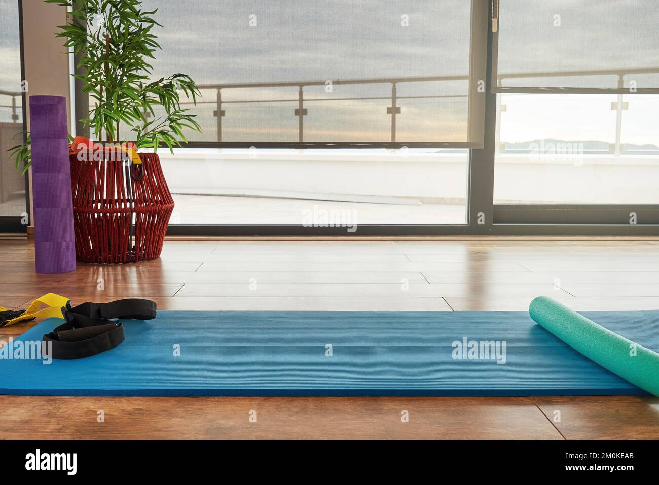 Sunlit fitness center with exercise mat and sport equipment. Wide open ...