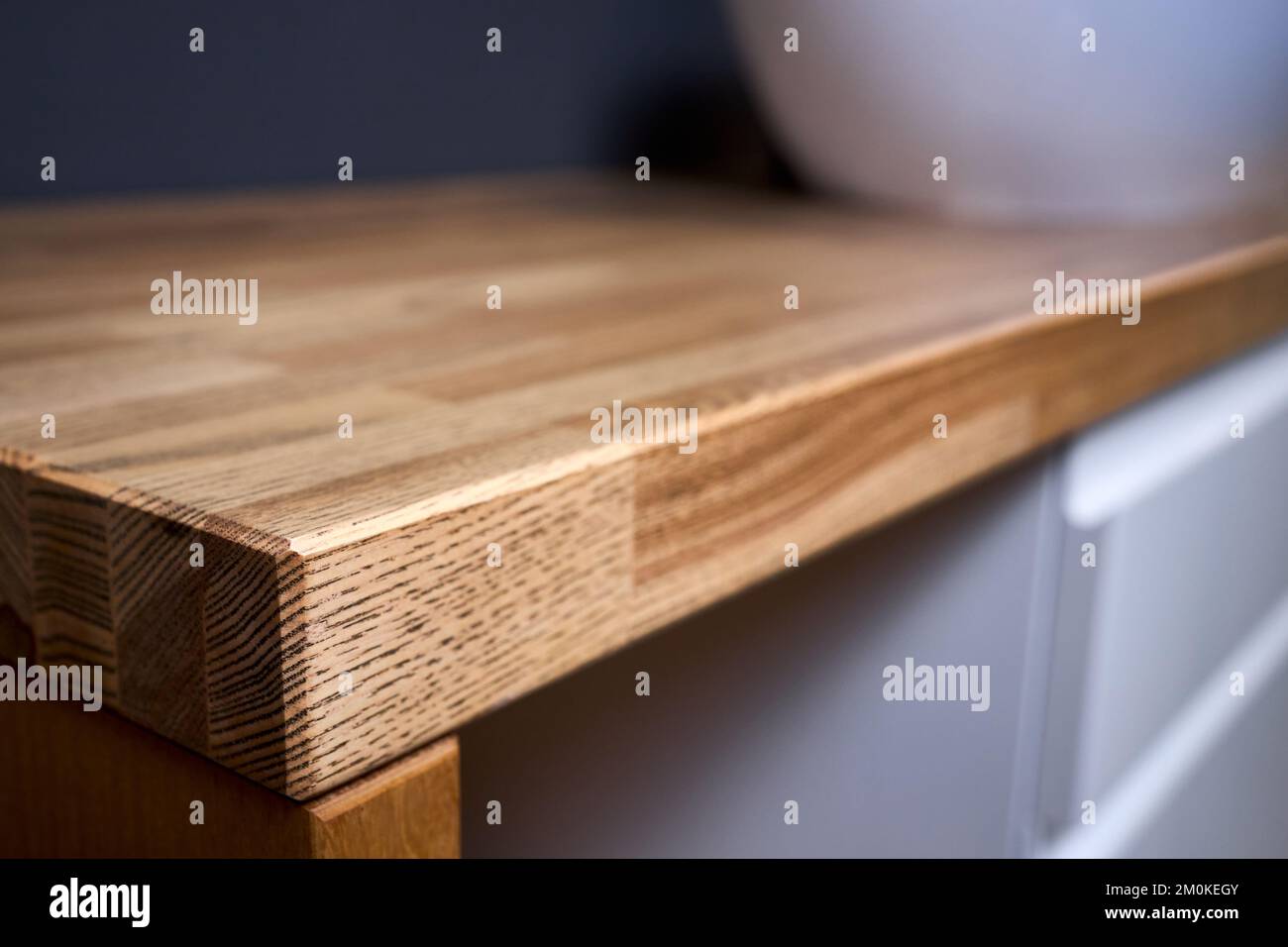 Solid ash glued timber corner table top closeup. Bathroom interior ...