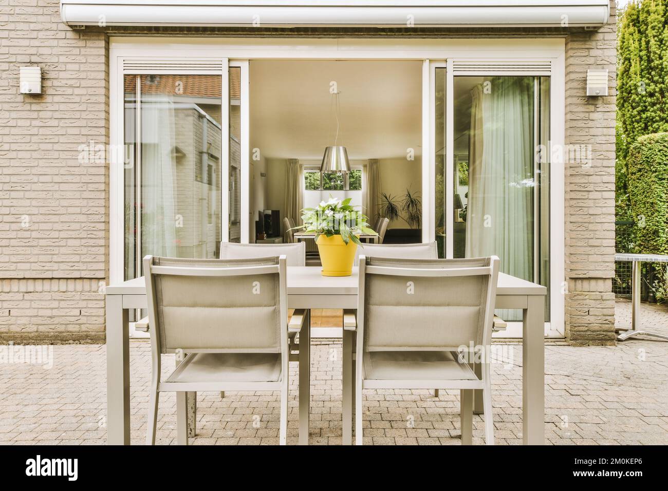 Neat paved patio with sitting area and small garden near wooden fence ...