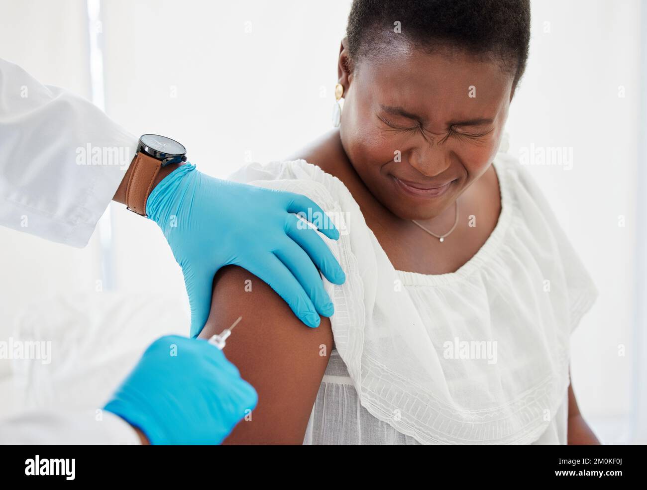 Patient in pain while being injected. Doctor giving a patient a vaccine ...