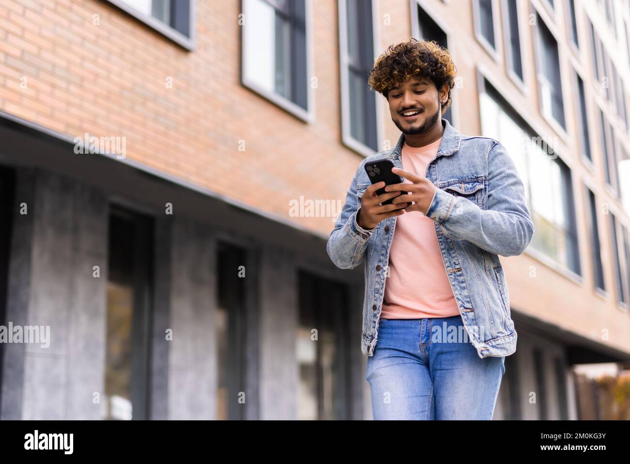 Handsome smiling young businessman reading text message on his phone ...