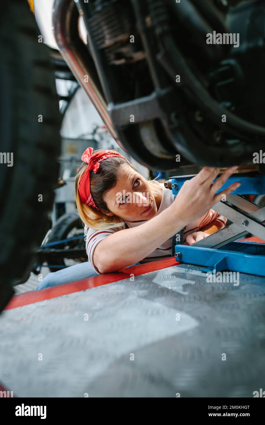 Mechanic woman checking motorcycle over platform Stock Photo - Alamy
